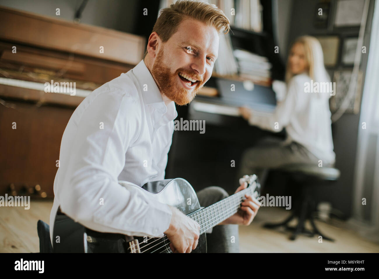 Young piano player accompanied by a handsome male guitarist Stock Photo ...