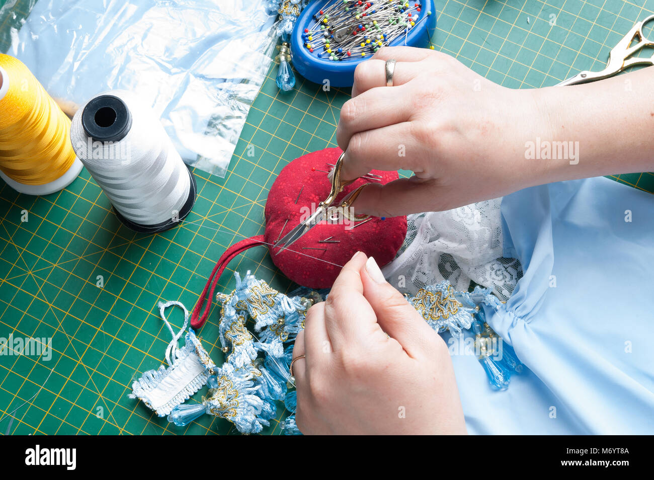 seamstress cuts the thread with sewing scissors Stock Photo - Alamy