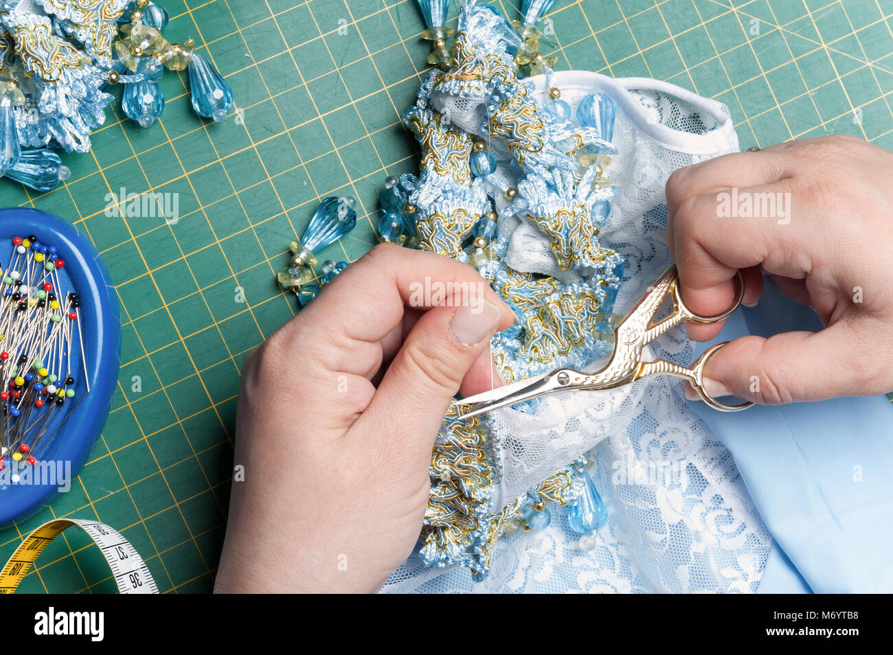 seamstress cuts the thread with sewing scissors Stock Photo - Alamy