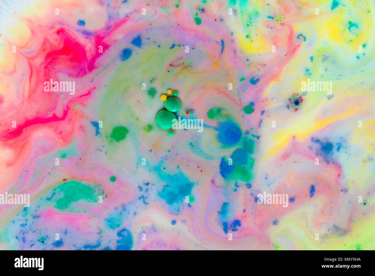 Abstract background, red and green color mix together in milk. Macro ...