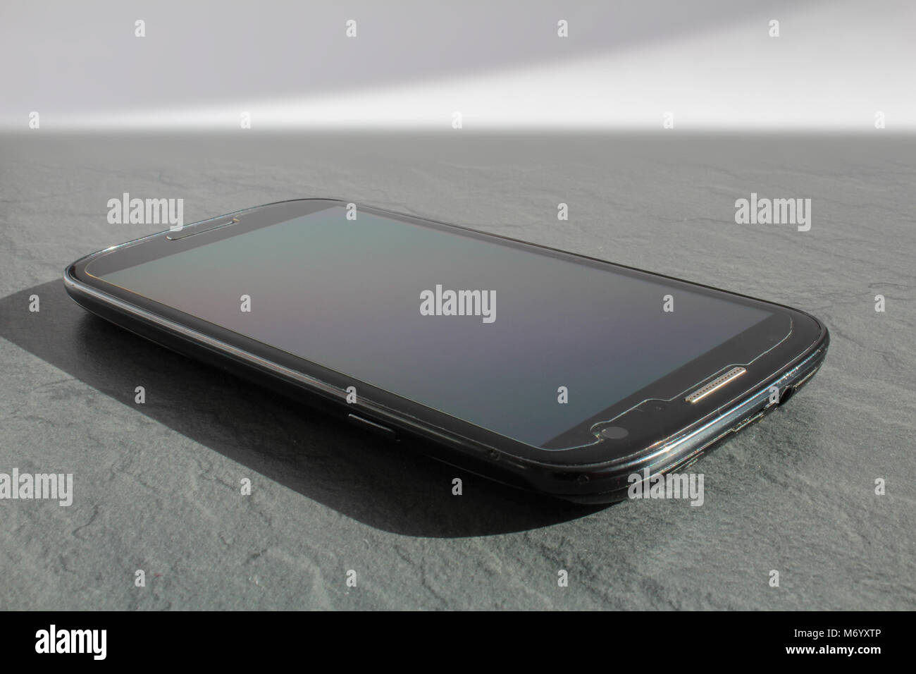 Mobile phone on dark grey stone texture, close up photo Stock Photo - Alamy