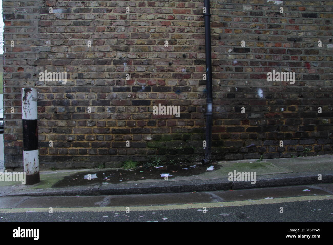 Black and white post against brickwall Stock Photo - Alamy