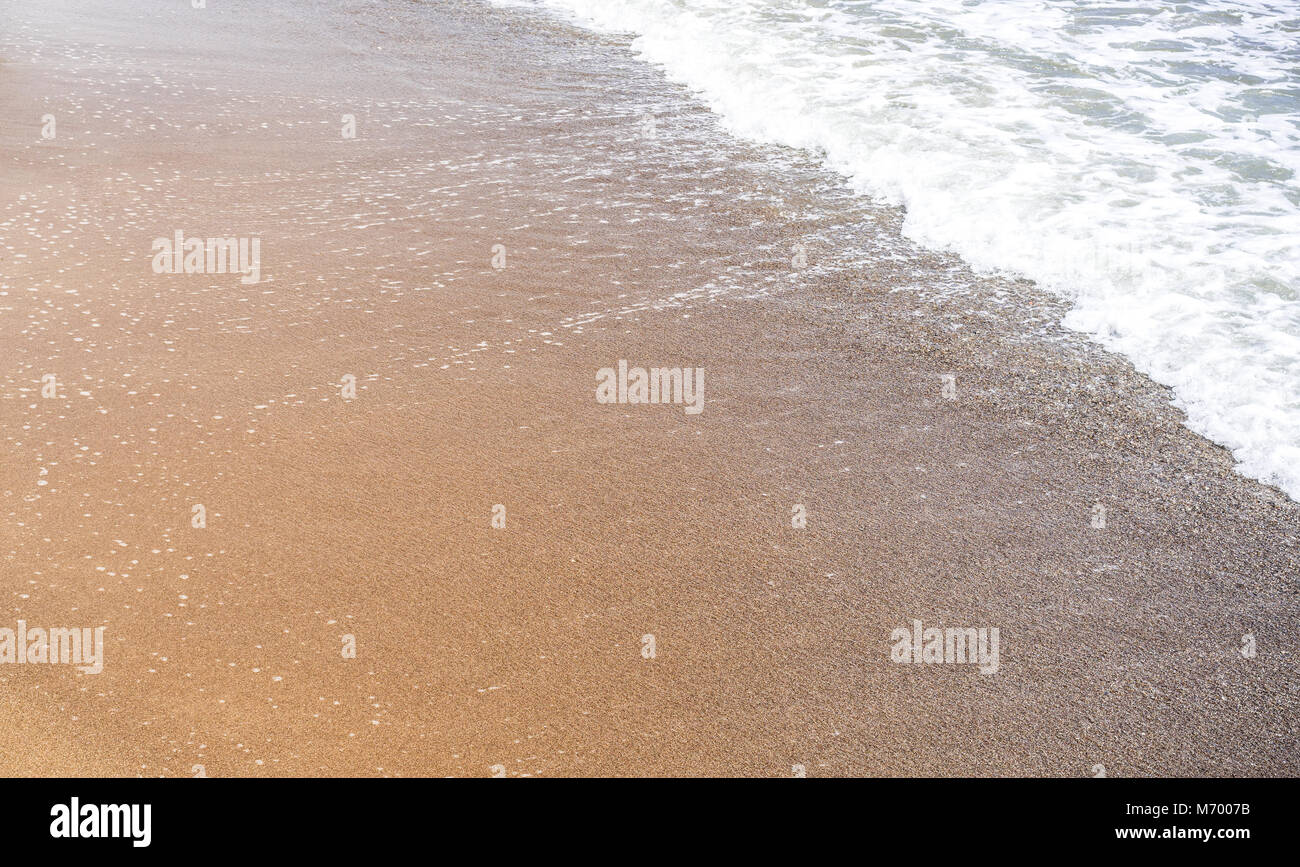 Sand and wave Stock Photo - Alamy
