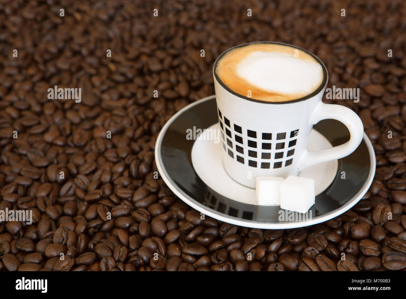 Single small espresso coffee cup on roasted coffee beans background ...
