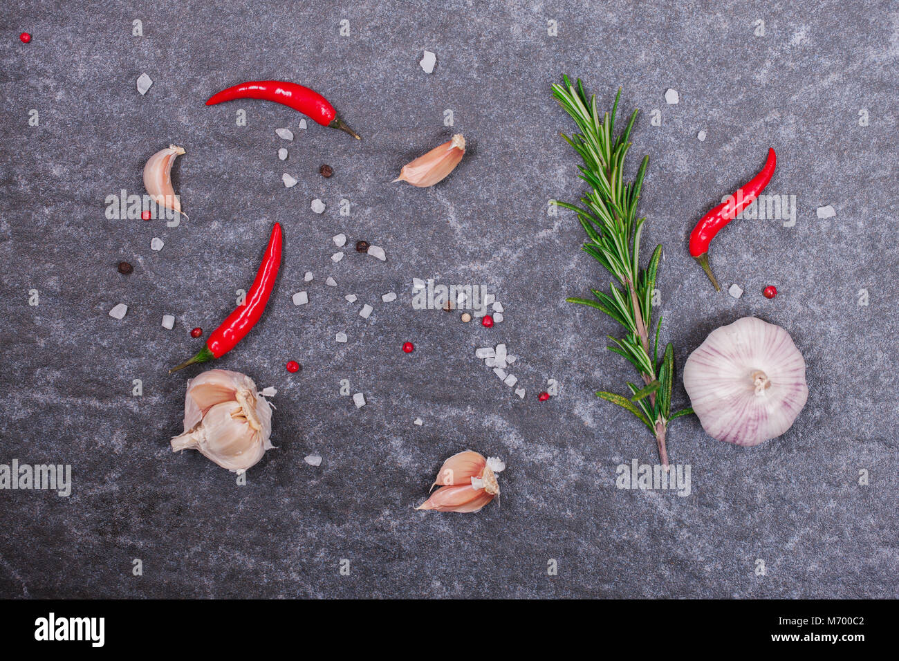 spices on the table top view- rosemary, red onion, garlic and red ...