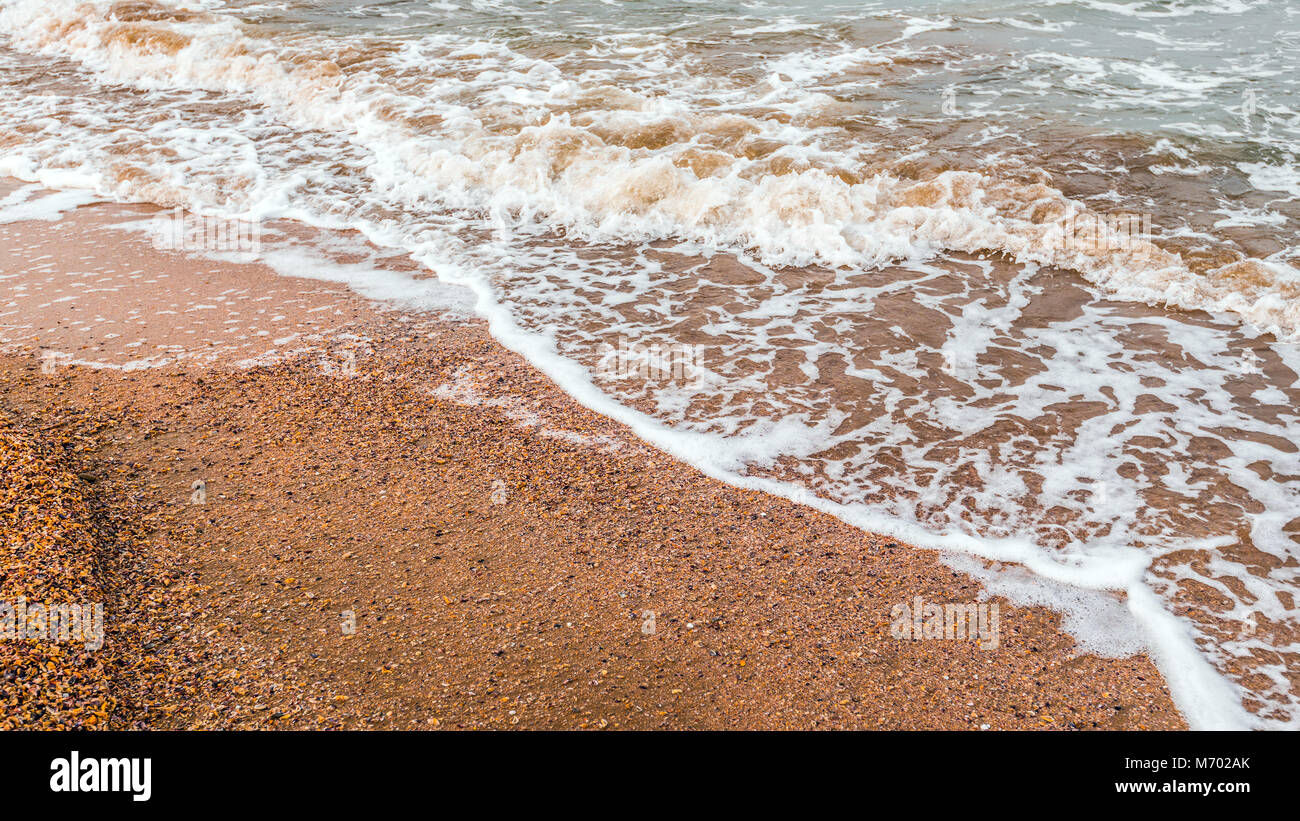 Golden sand and sea wave background Stock Photo - Alamy