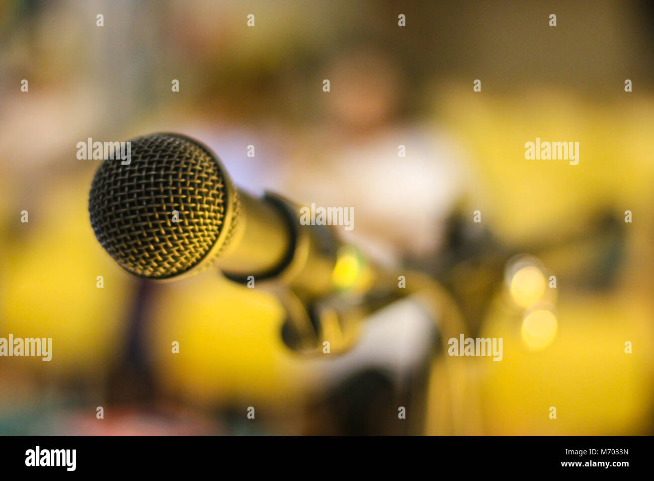 A concert microphone with yellow spotlight, background and texture ...