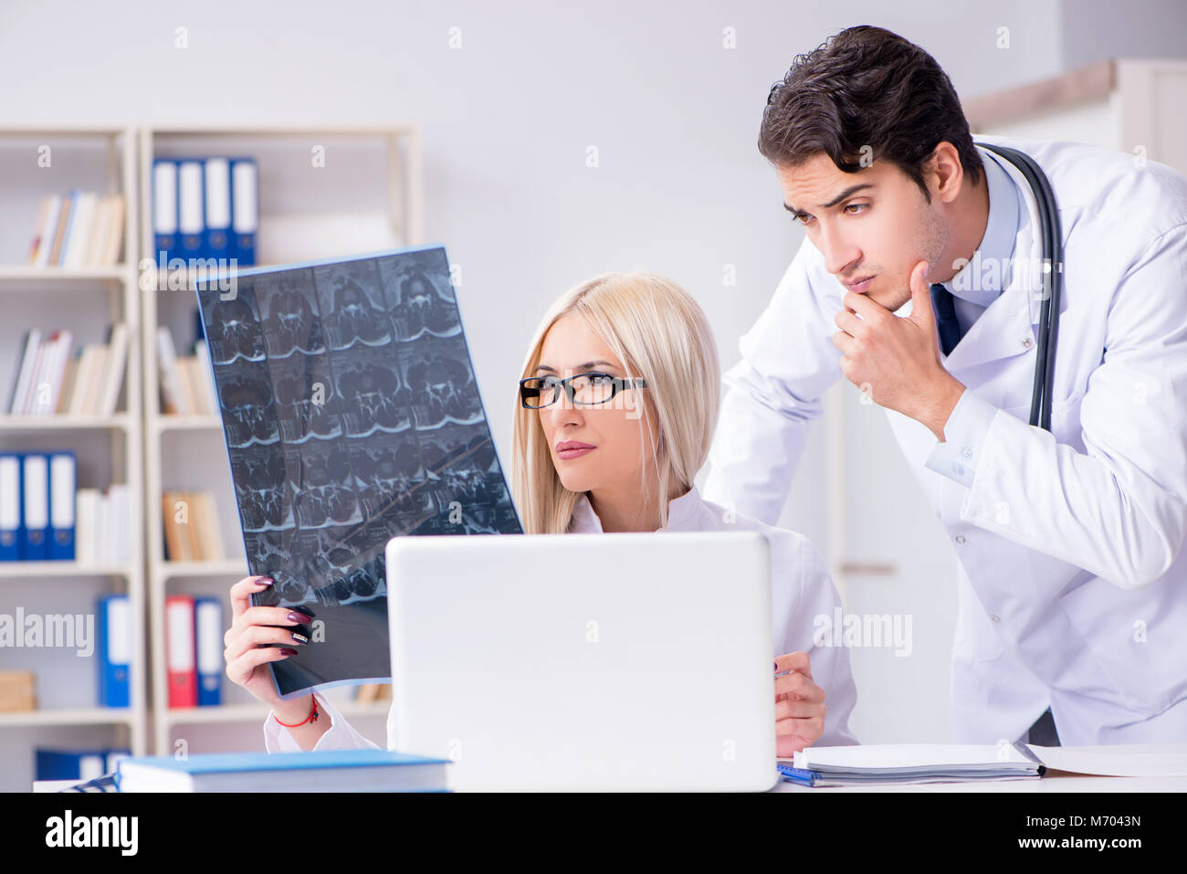 Two doctors examining x-ray images of patient for diagnosis Stock Photo ...