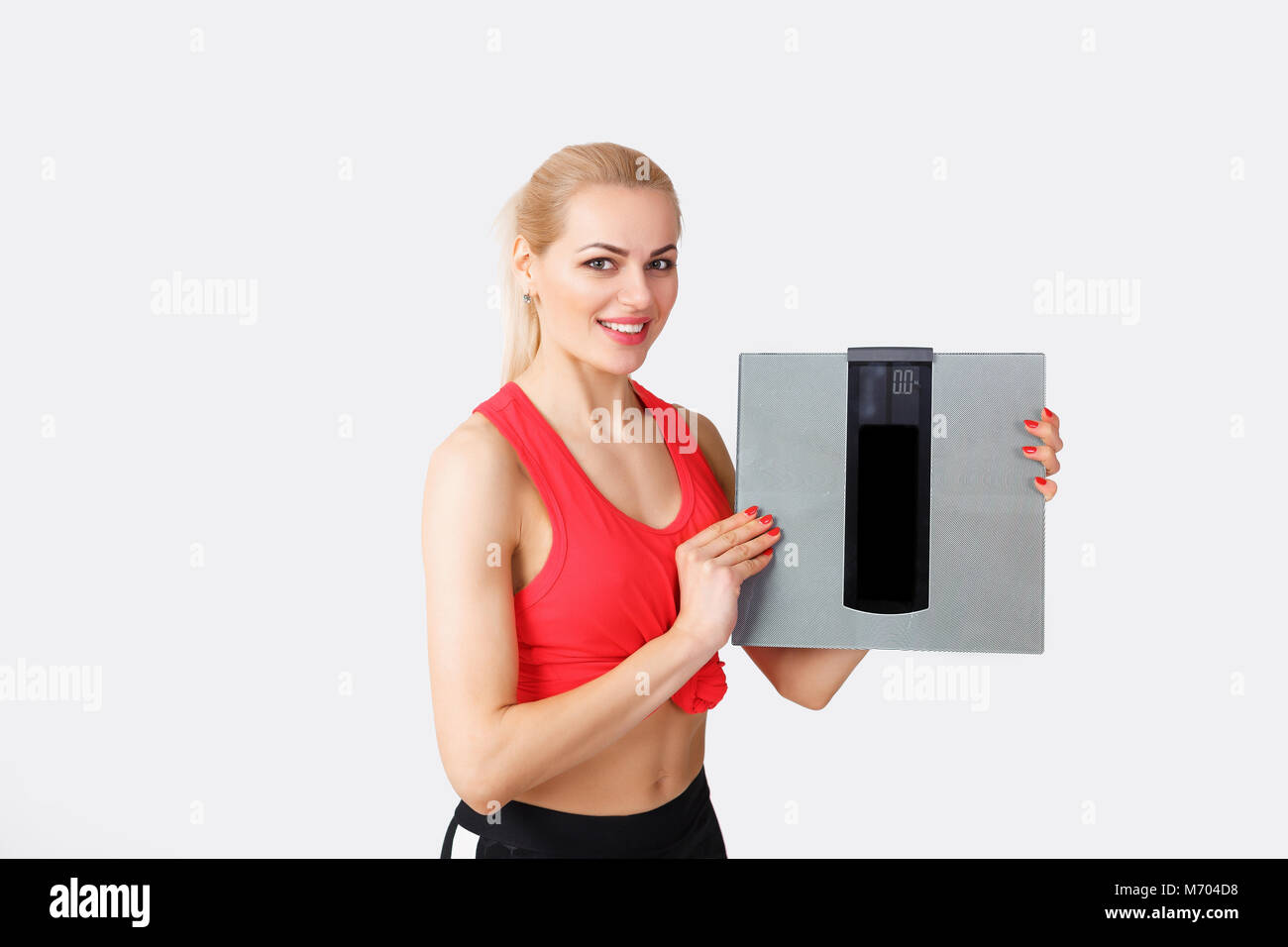 athletic woman holding scales Stock Photo - Alamy
