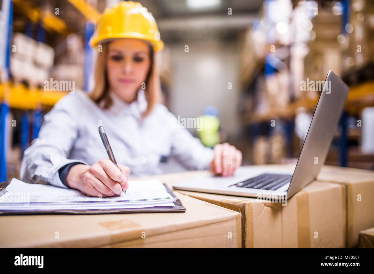 Young warehouse worker with laptop working Stock Photo - Alamy