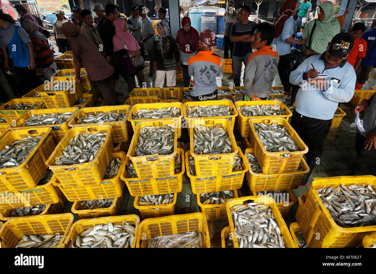 Batang, Indonesia. 07th Mar, 2018. A checker inspects buckets a fish at ...