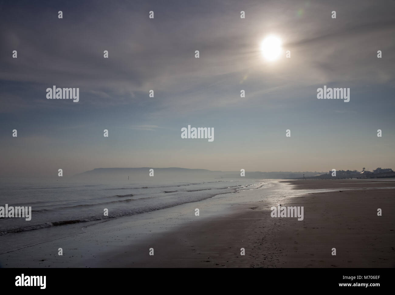 Sun shining through thin clouds over Sandown Beach looking towards a ...
