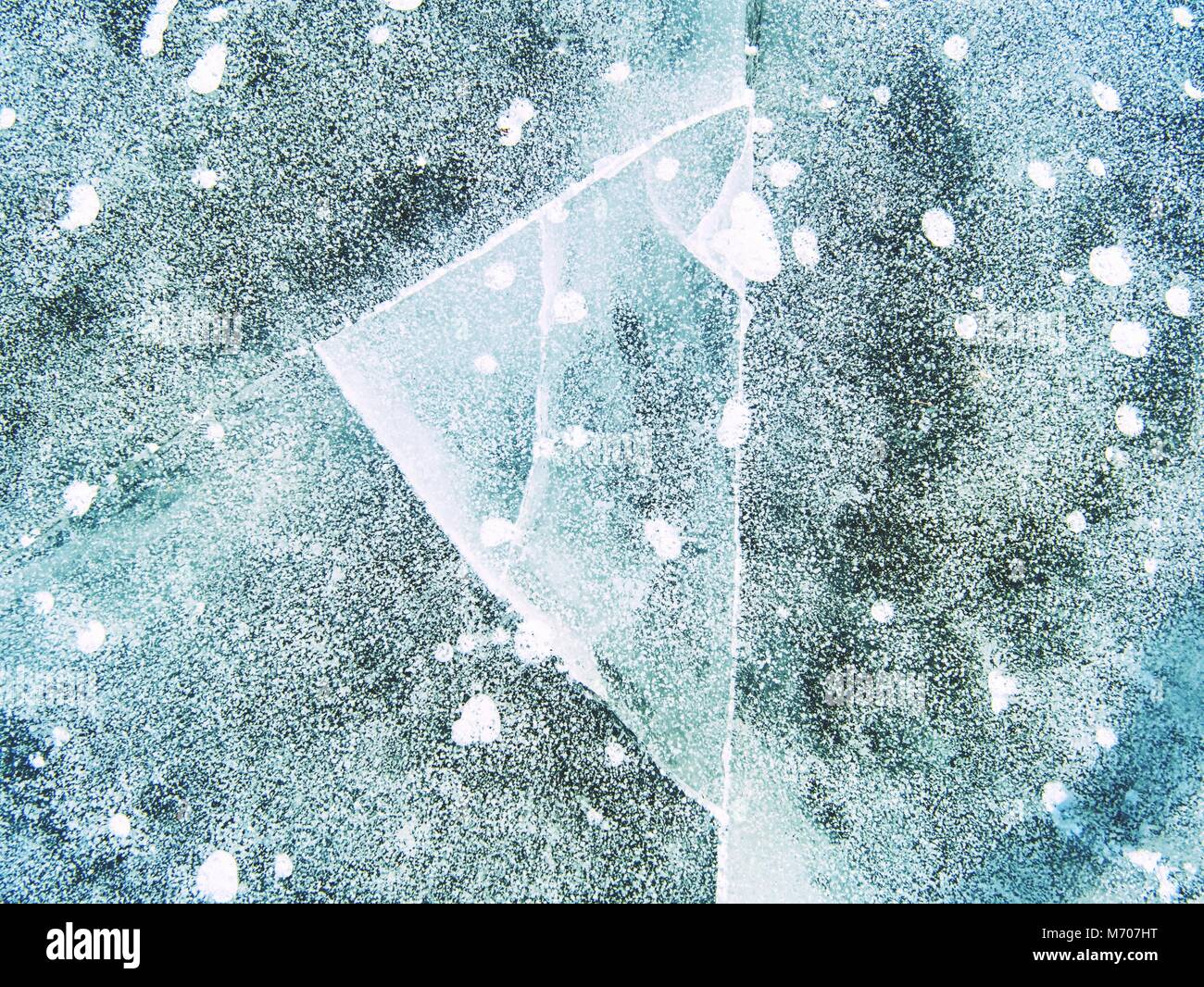 Follow bubbles and crack in the ice on the lake.Reflection of sun rays ...