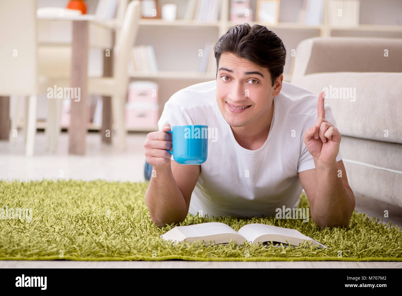 Man reading book at home on floor Stock Photo - Alamy