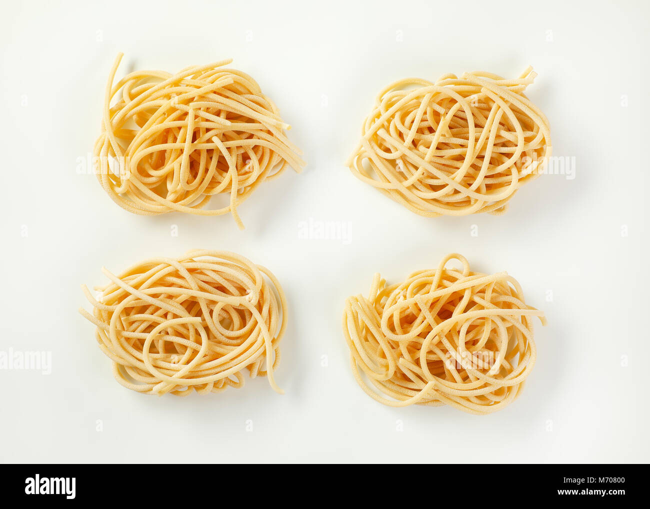 four bundles of uncooked spaghetti pasta on white background Stock ...