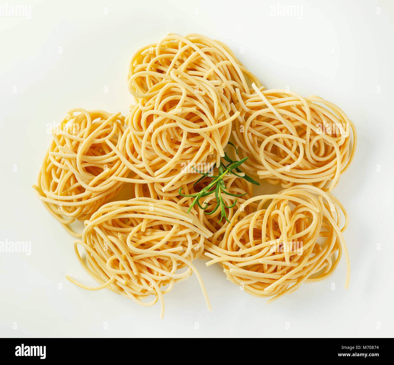 bundles of uncooked spaghetti pasta on white background Stock Photo - Alamy