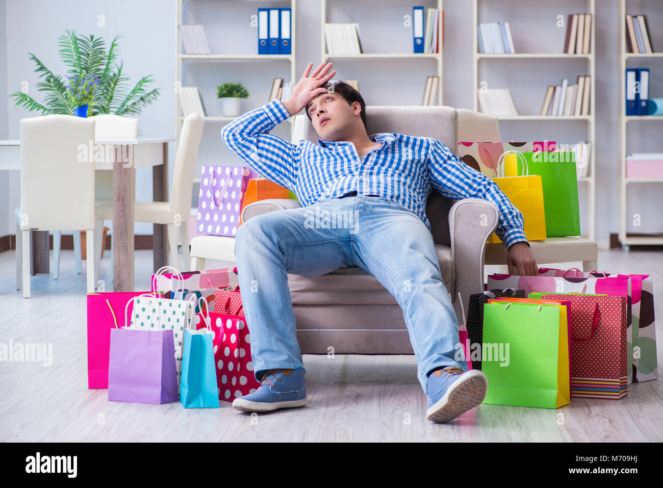 Young man after excessive shopping at home Stock Photo - Alamy