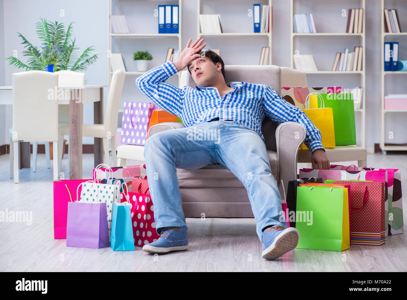 Young man after excessive shopping at home Stock Photo - Alamy