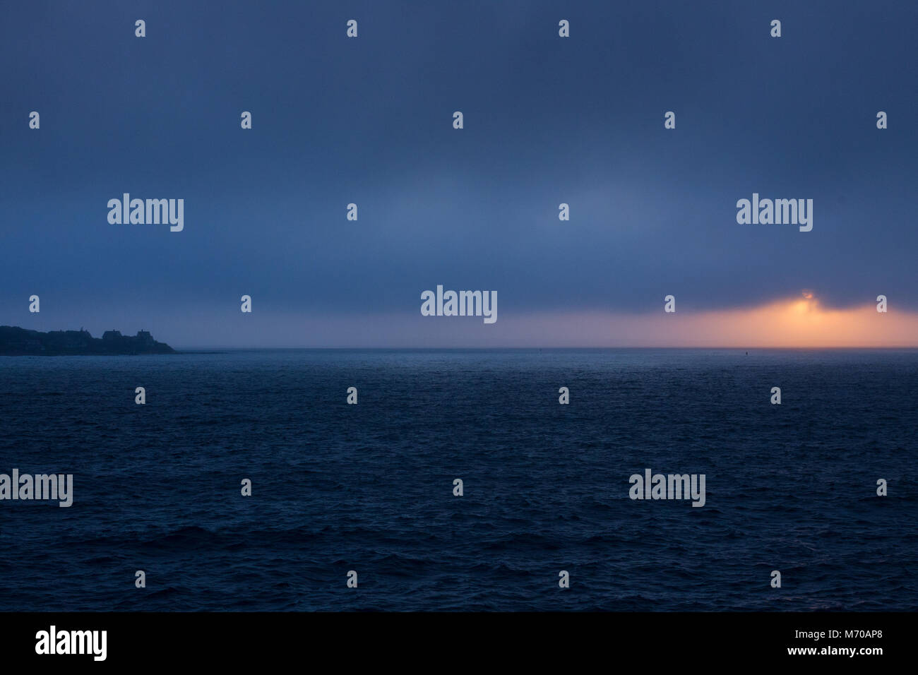 Sun sets beneath storm clouds in the Vineyard Sound off of Martha's ...
