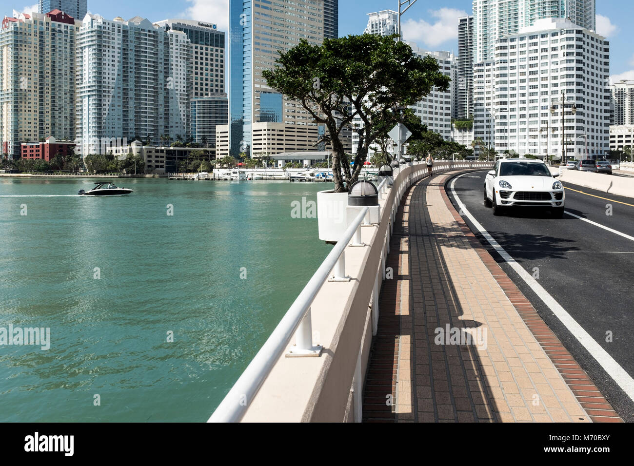 Car crossing and boat going under Brickell Key bridge with downtown in ...