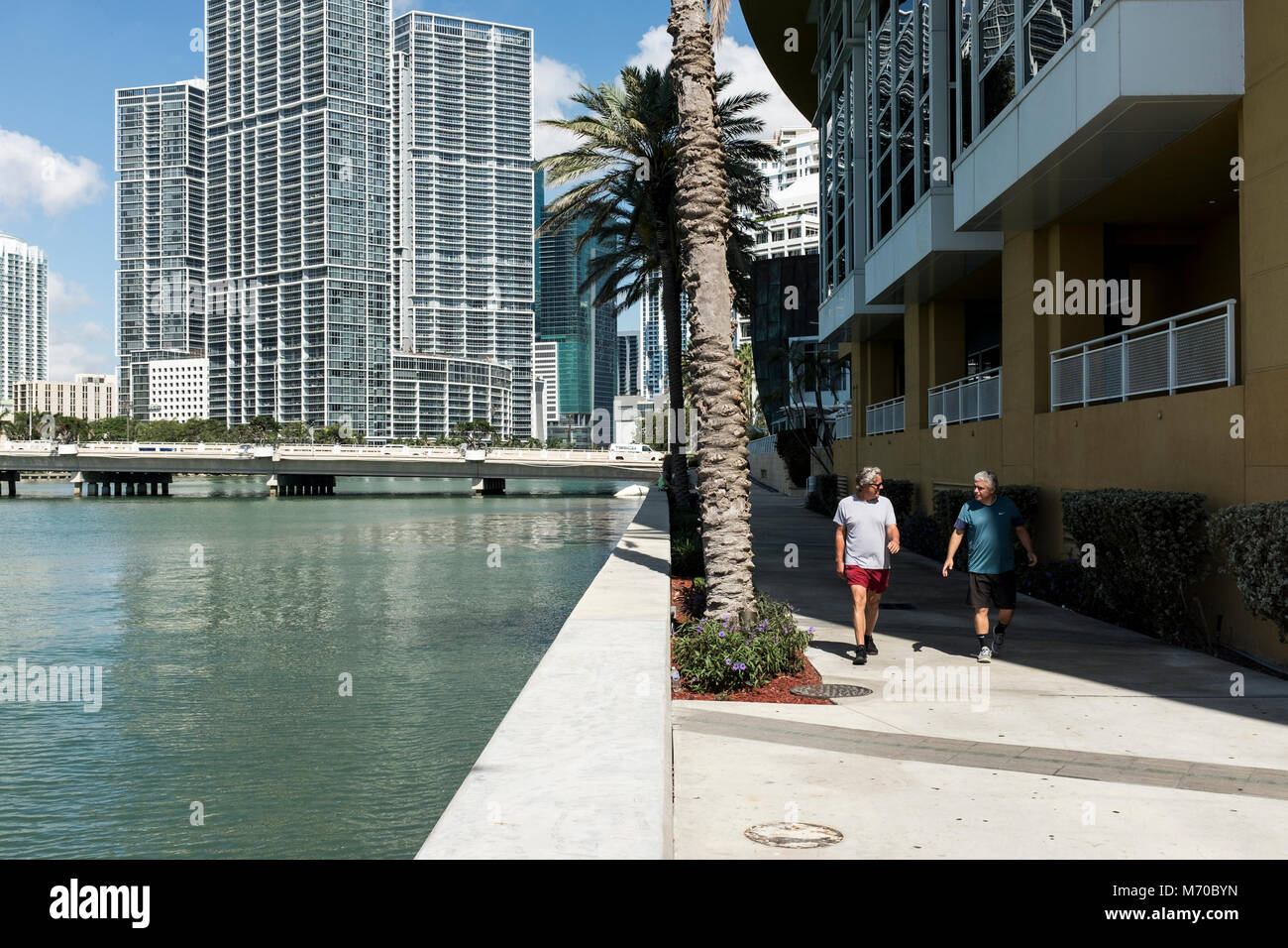 Men walking along waterfront with downtown in the background in ...