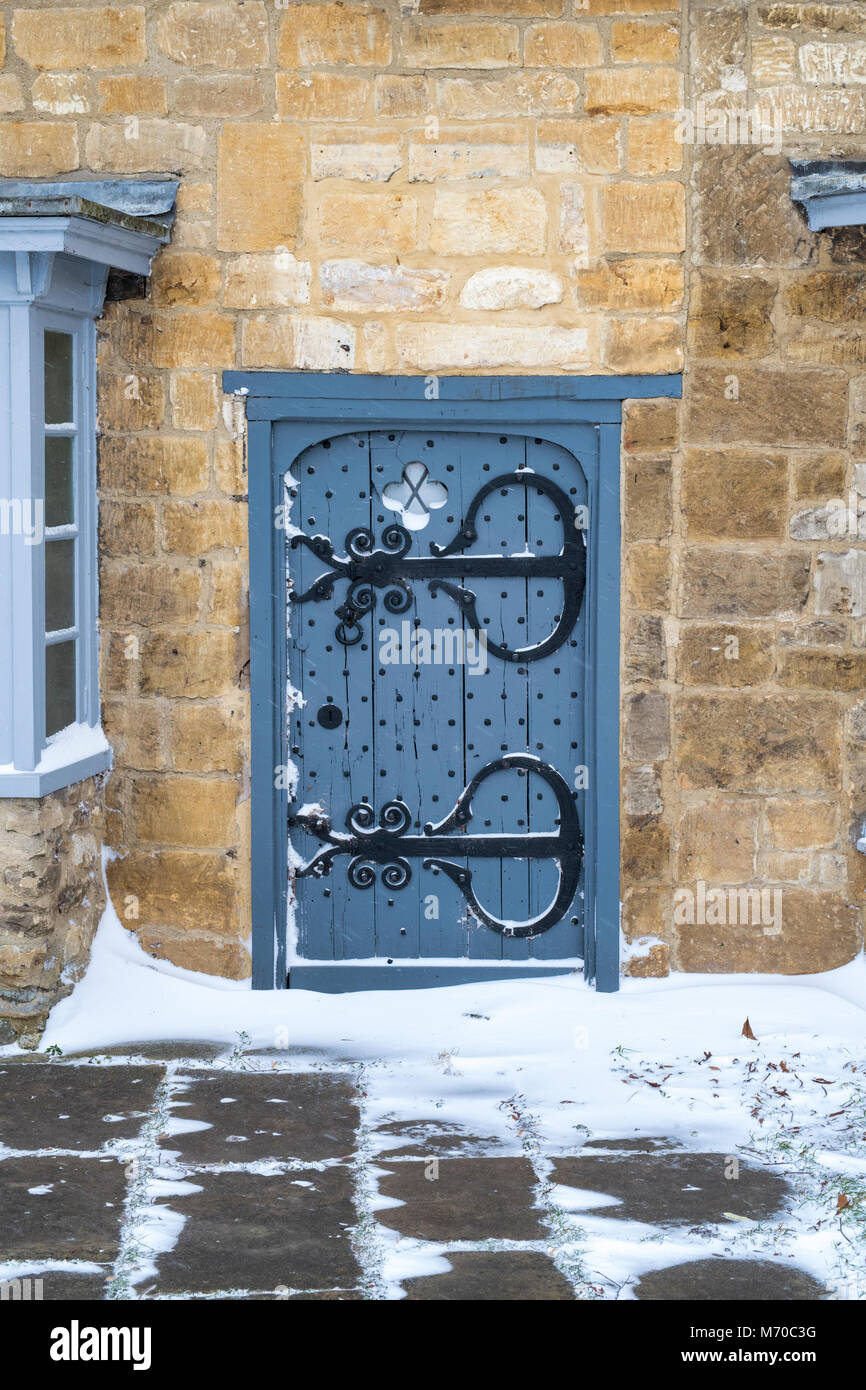 Broadway stone cottage grey studded wooden door in the winter snow ...