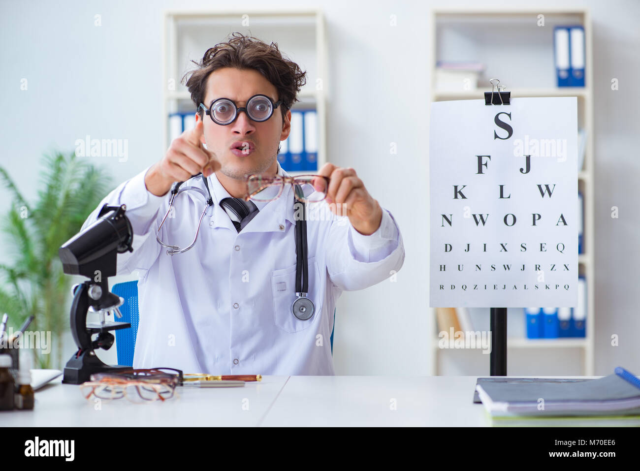 Funny eye doctor in humourous medical concept Stock Photo - Alamy