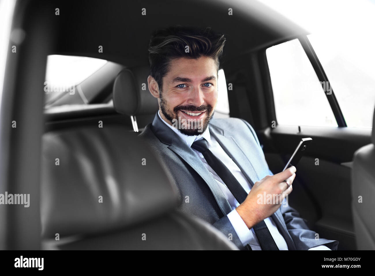businessman smiling while sitting in the back seat in the car Stock ...