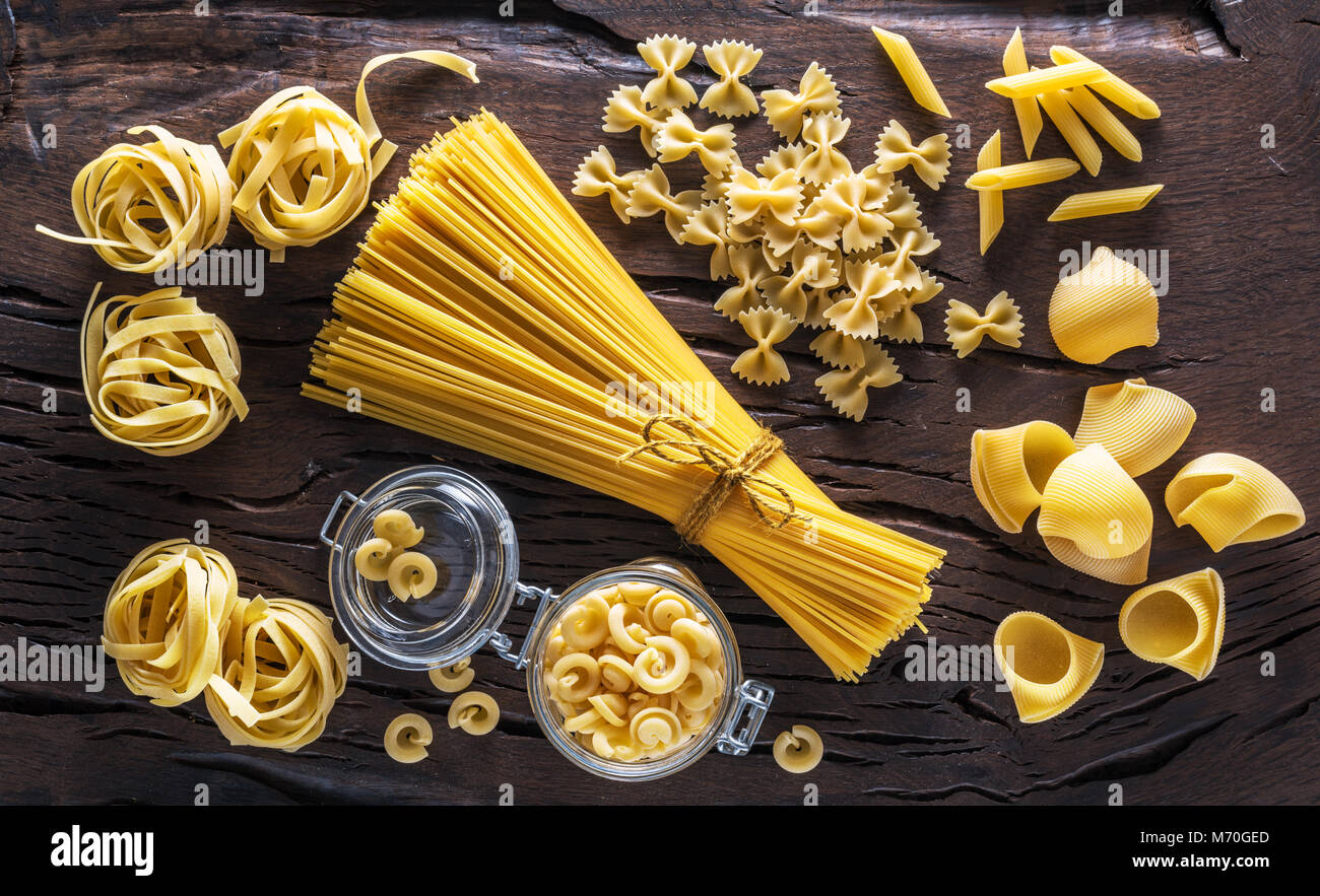 Different pasta types on the wooden table Stock Photo - Alamy