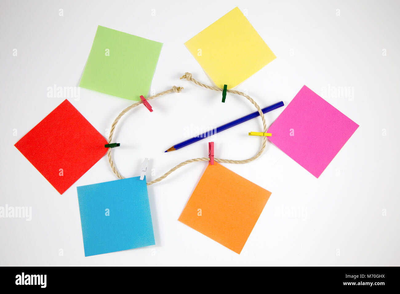 Post-it notes with small colored pegs in a rope and ablue pencil in ...