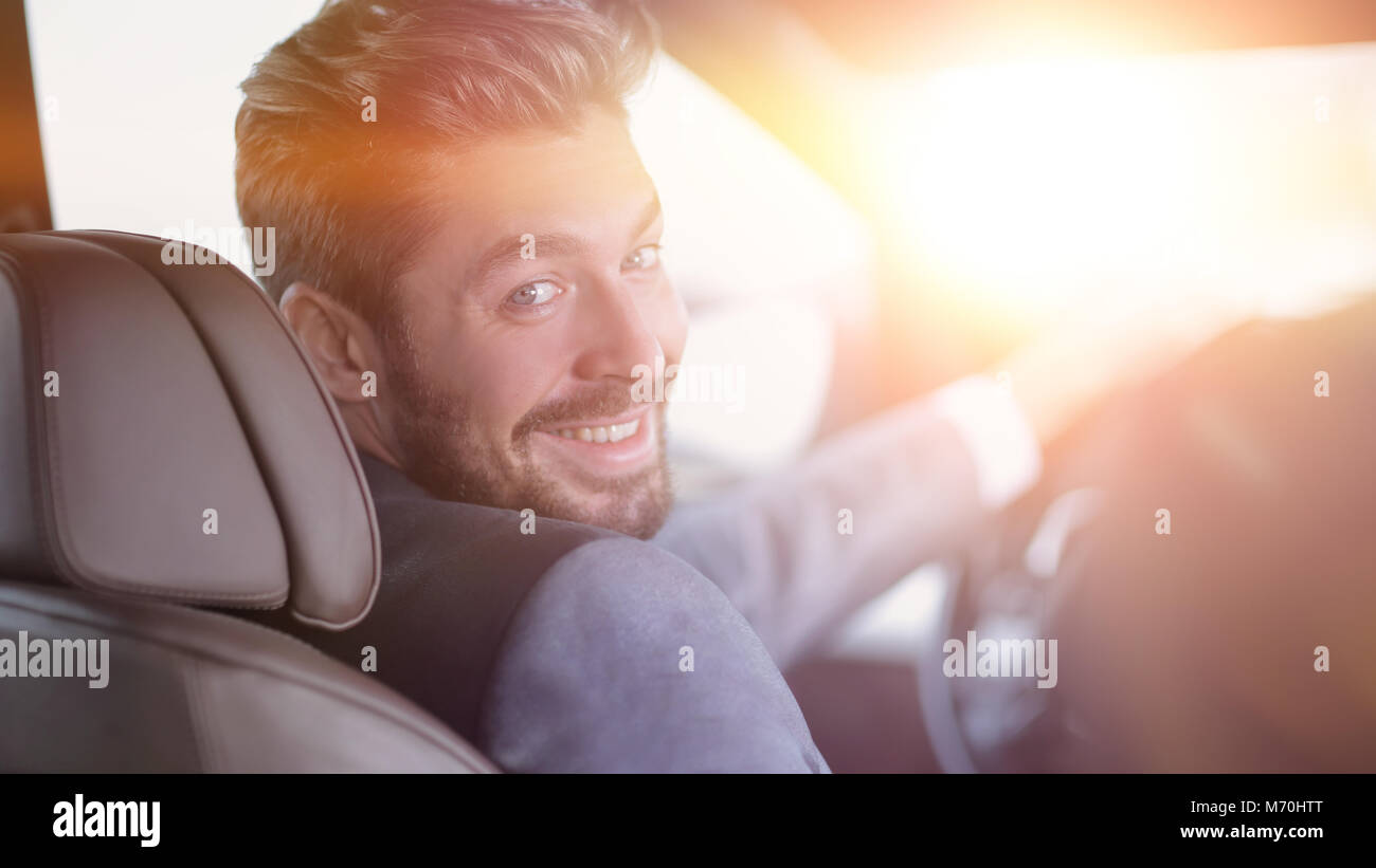 rear view, young man driving his car, looking at camera Stock Photo - Alamy