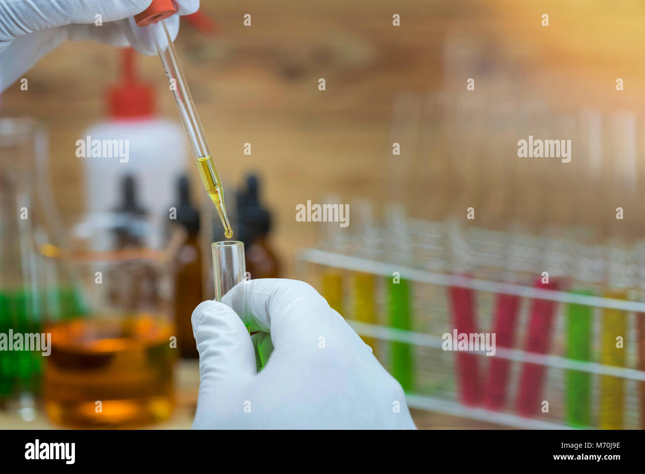 Researcher is dropping the reagent into test tube.Scientist working at ...