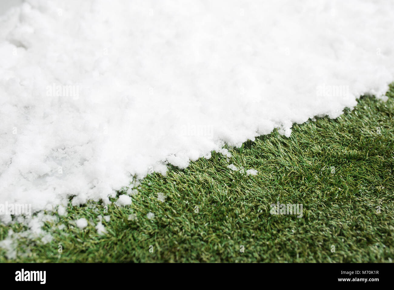 Meeting snow on green grass close up - between winter and spring ...