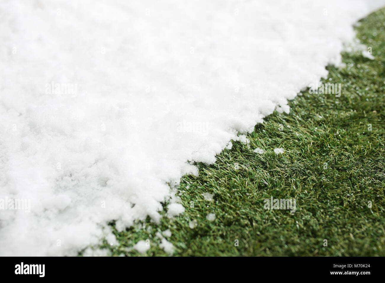 Meeting snow on green grass close up - between winter and spring ...