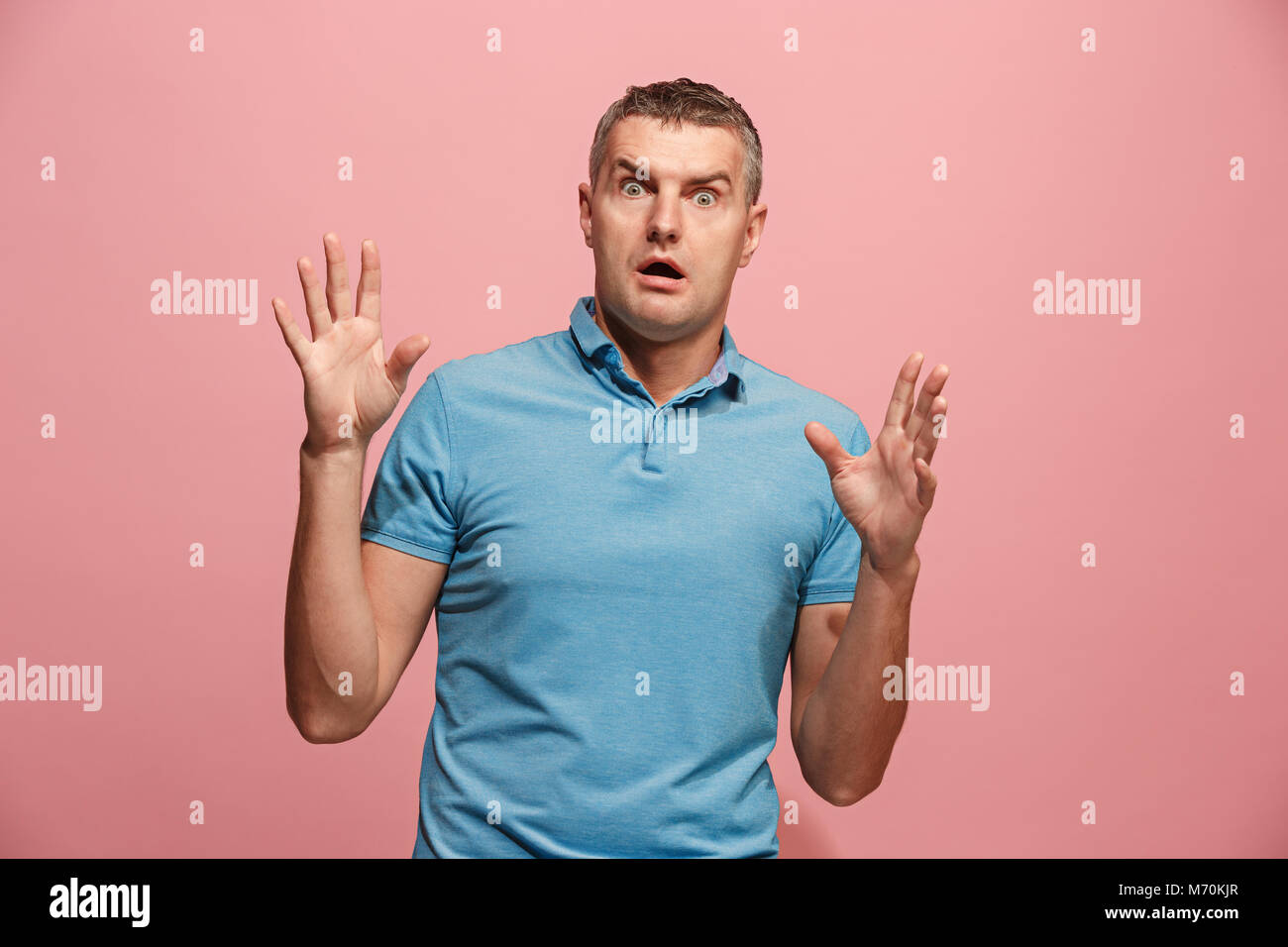 Portrait of the scared man on pink Stock Photo - Alamy