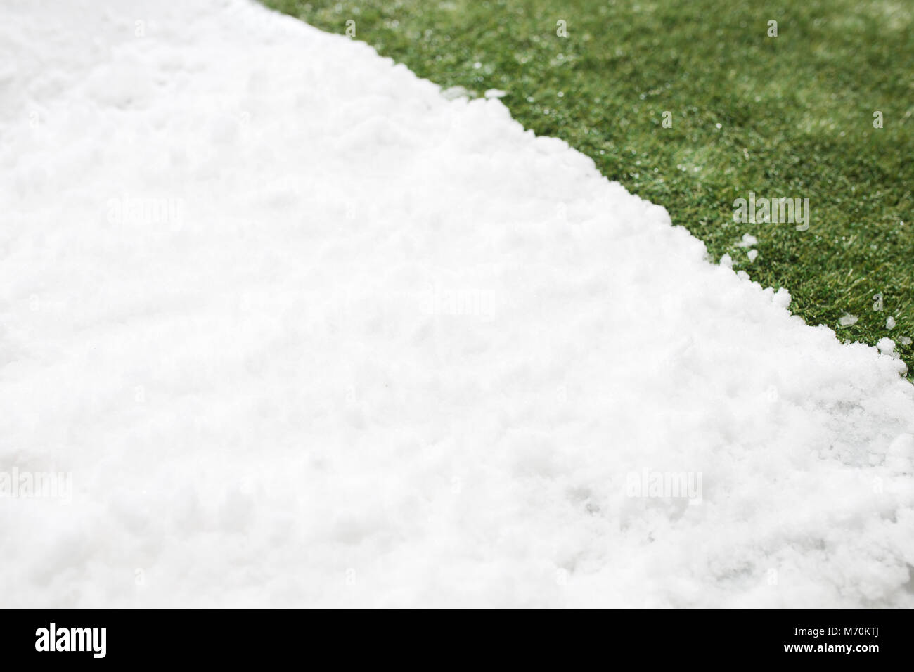 Meeting snow on green grass close up - between winter and spring ...