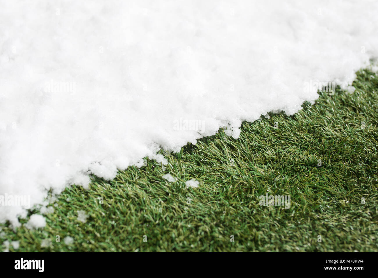 Meeting snow on green grass close up - between winter and spring ...
