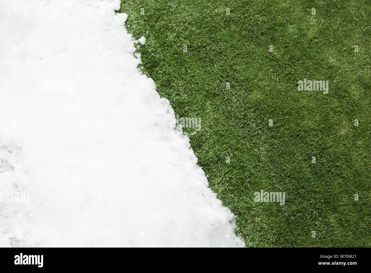 Meeting snow on green grass close up - between winter and spring ...