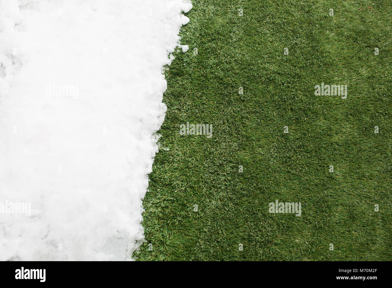 Meeting snow on green grass close up - between winter and spring ...
