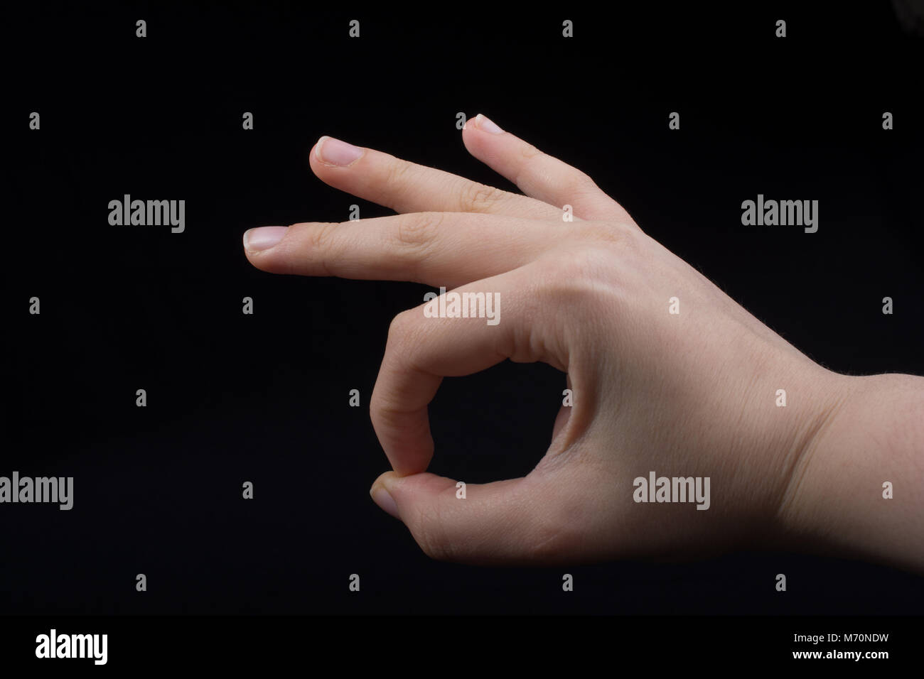 Hand gesturing sign ok okay agree on black background Stock Photo - Alamy