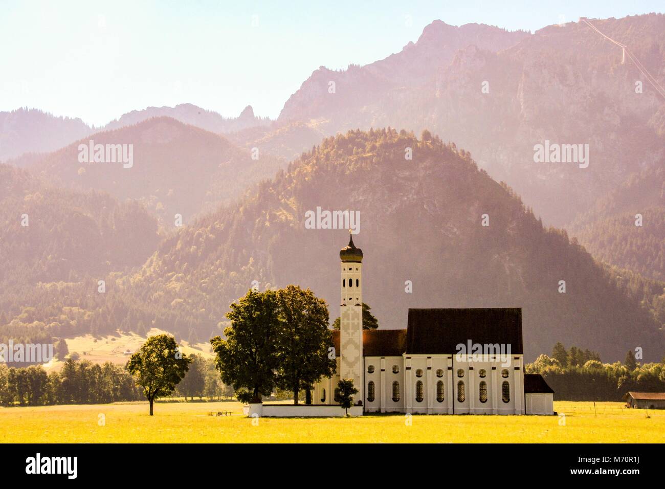 church surrounded by mountains in a typical bavarian landscape on the ...
