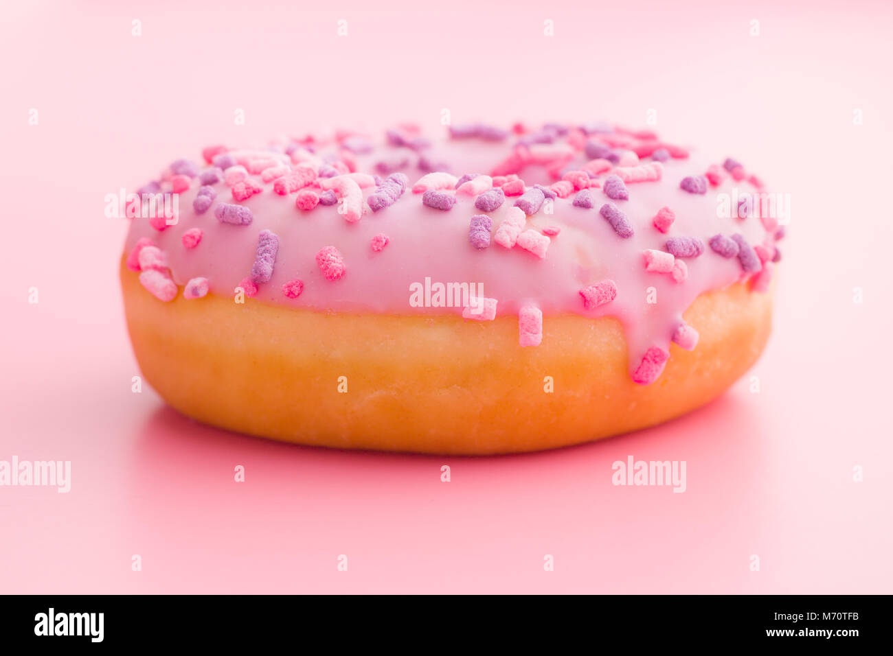 One pink donut on pink background Stock Photo - Alamy