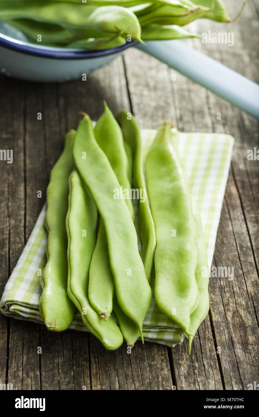 Green string beans pods on old wooden table Stock Photo - Alamy