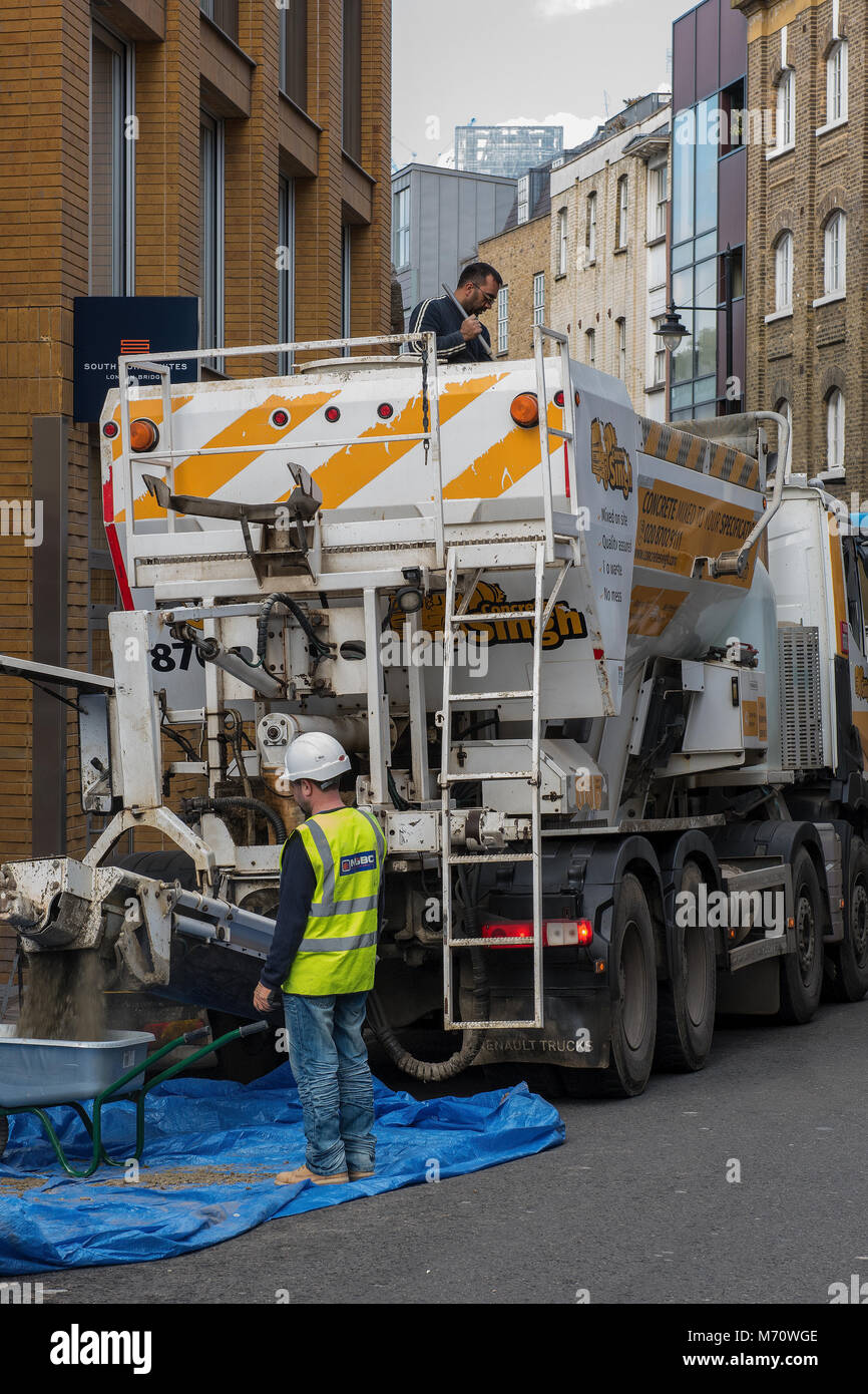 construction workers and builders on a site in central london pouring ...