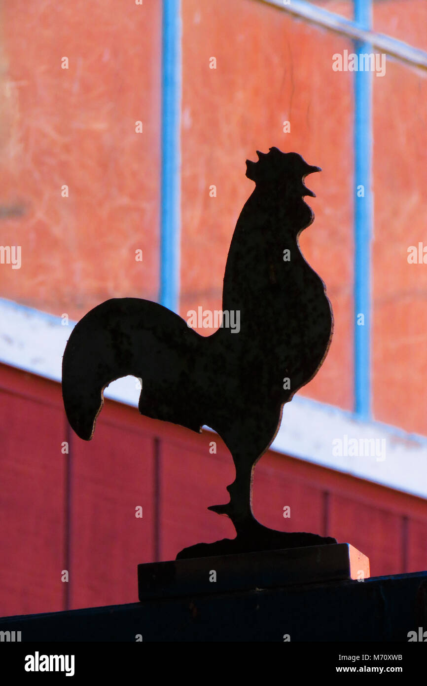 Rooster weathervane seen alongside a red painted barn Stock Photo - Alamy