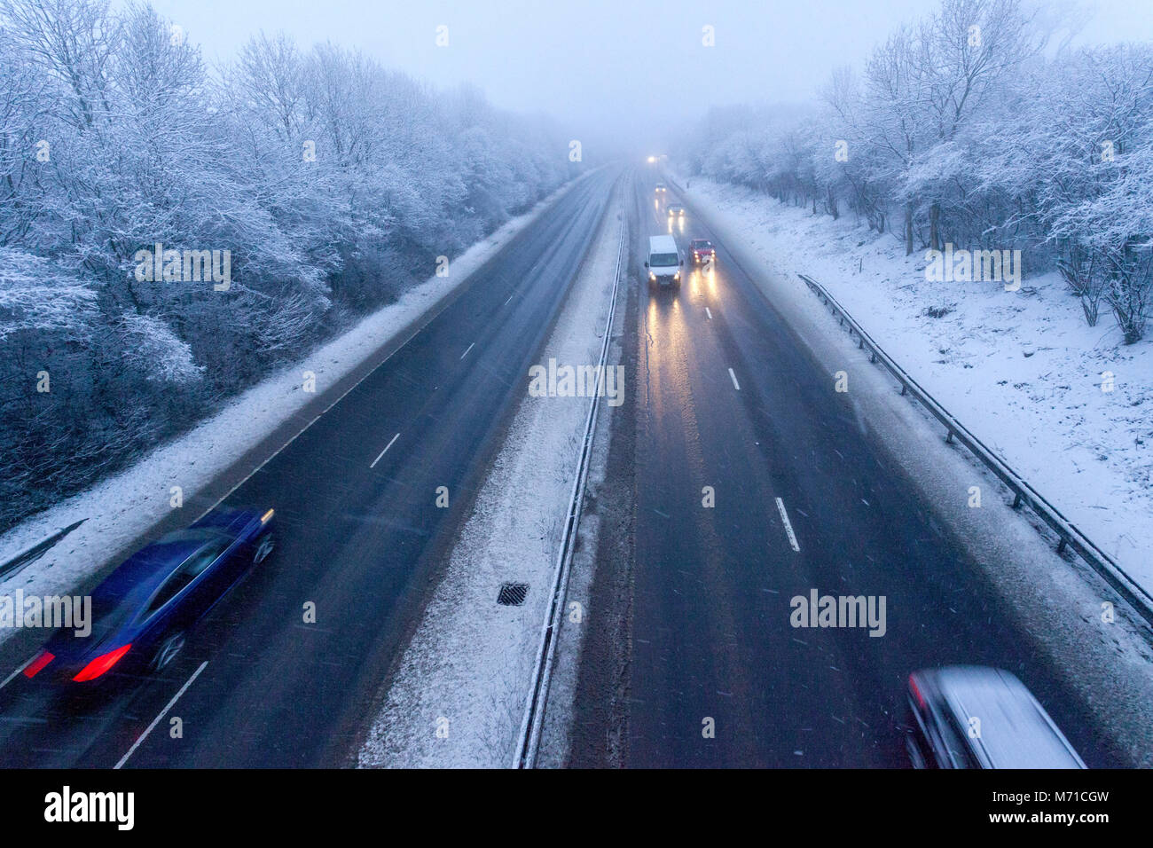 Traffic travelling along a snow covered A55 road as it passes through ...