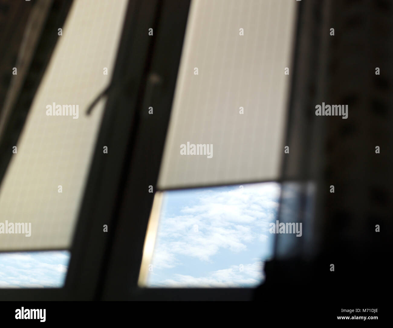 Piece of the cloudy sky through the window, cropped low angle shot ...