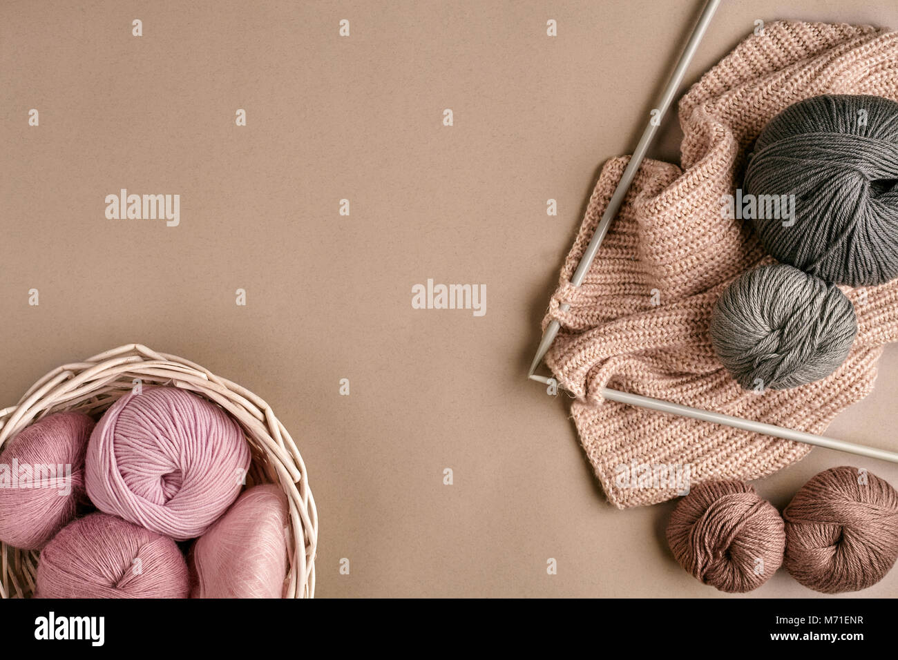 Balls of merino wool yarn, knitting on knitting needles on a beige ...