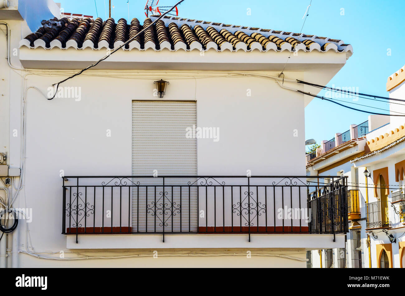 Stylish balcony with a metal railing, solid architectural element, a ...