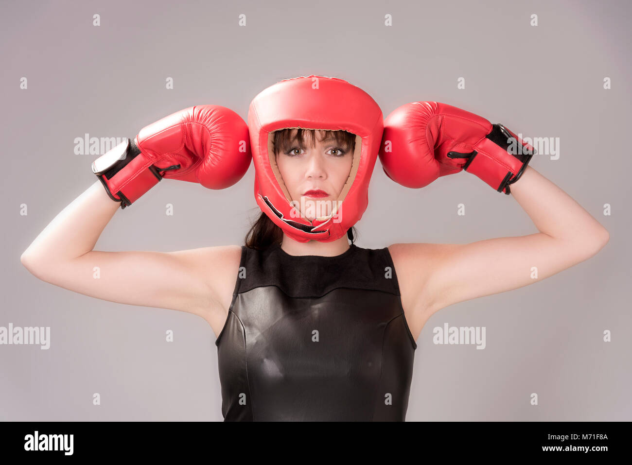 Woman boxer with an facial expression wearing a red headguard and red ...